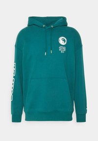 Puma STAPLE HOODIE - Sudadera - malachite/azul petróleo - Zalando.es