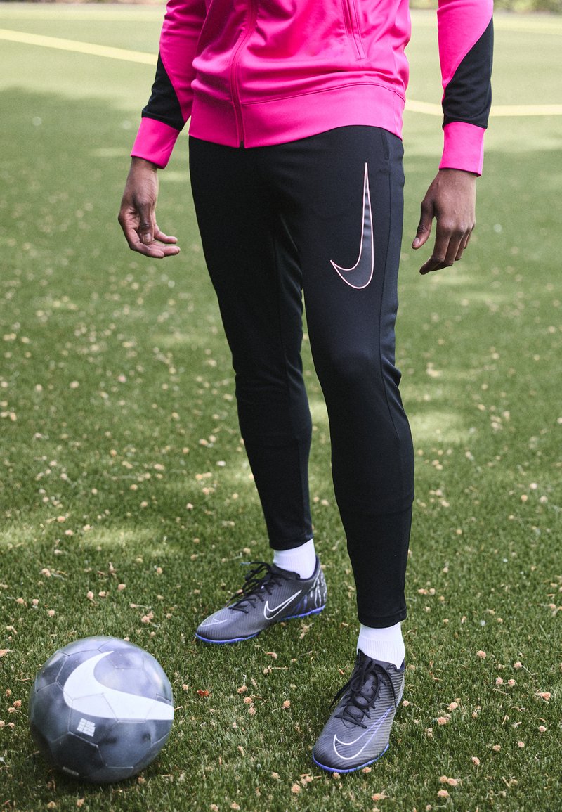 Nike Performance ACADEMY PANT - Tracksuit bottoms - black/sunset pulse ...