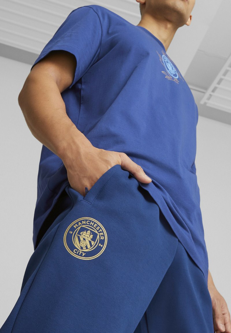 Puma MANCHESTER CITY CNY - Tracksuit bottoms - blazing blue team light ...