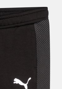 Puma EVOSTRIPE PANTS UNISEX - Jogginghose - black/schwarz - Zalando.ch