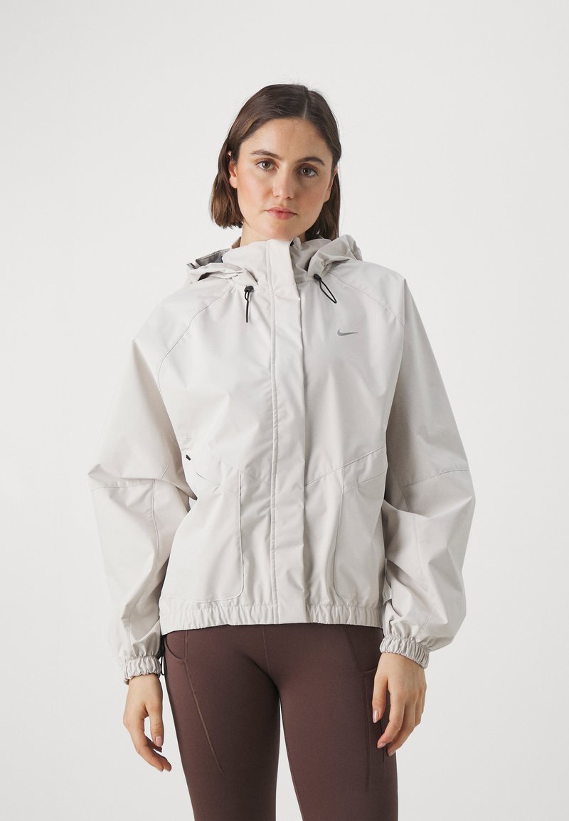Nike Performance SWIFT - Running jacket - light orewood brown/black ...