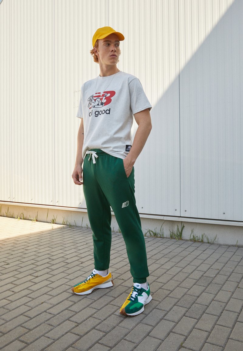 New Balance NB ESSENTIALS - Tracksuit bottoms - nightwatch green/dark ...