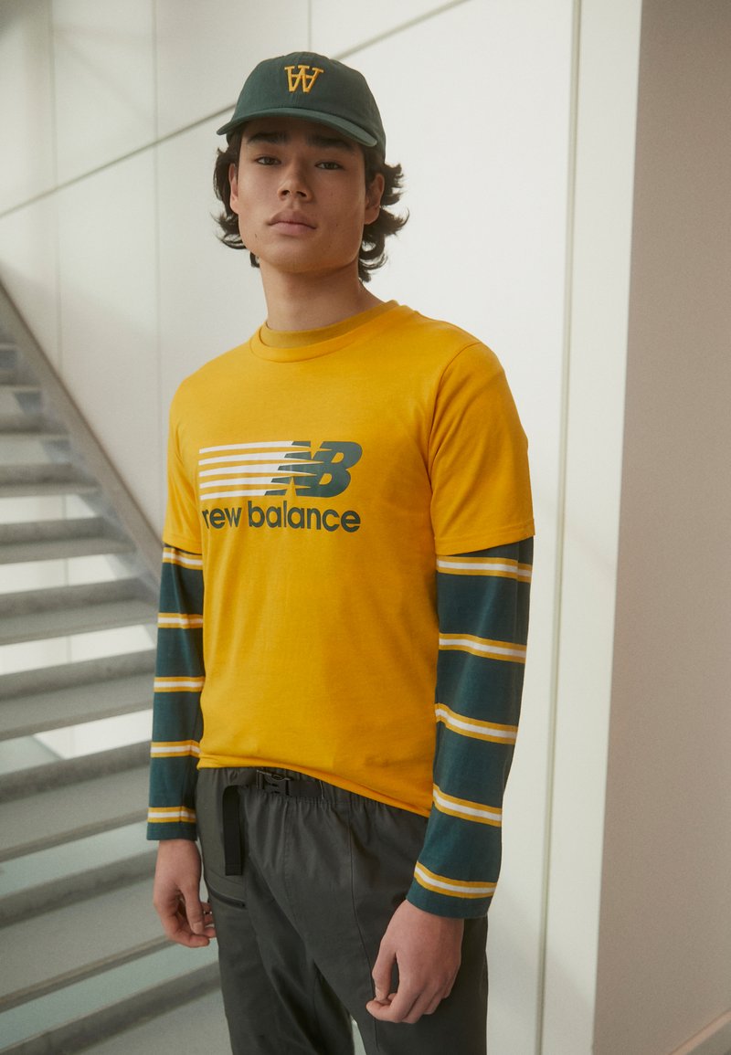 New Balance SPORT CORE PLUS GRAPHIC - T-Shirt print - gold-coloured ...