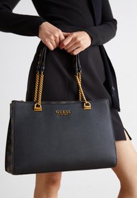 Guess FYNNA GIRLFRIEND CARRYALL - Borsa a mano - black/mocha logo/nero ...