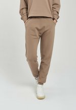 Zombie Dash HUNGRY ONE - Tracksuit bottoms - paloma brown/brown ...