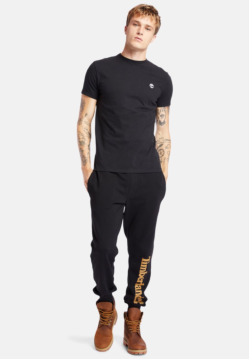Timberland CORE TREE LOGO SWEATPANT - Jogginghose - black/wheat boot ...