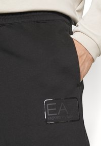 EA7 Emporio Armani TROUSERS - Pantalon de survêtement - black/noir - ZALANDO.CH