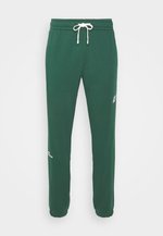 New Balance NB ESSENTIALS - Tracksuit bottoms - nightwatch green/dark ...