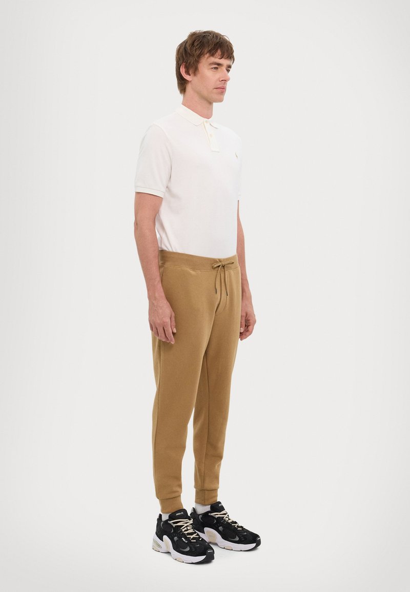 Polo Ralph Lauren ATHLETIC - Tracksuit bottoms - new bronze/bronze ...