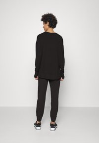 Athleta RAINIER HYBRID JOGGER - Jogginghose - black/schwarz - Zalando.ch