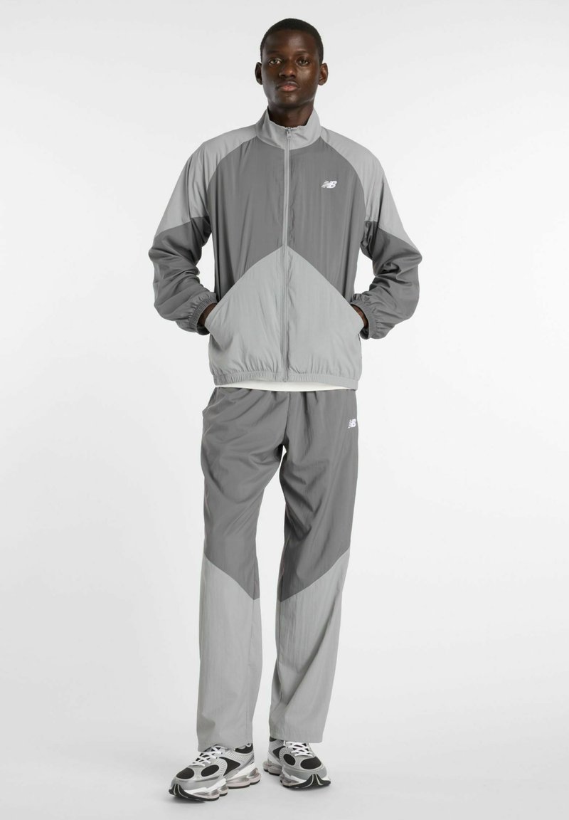 New Balance SPORT LEGACY - Tracksuit bottoms - castlerock slate grey ...