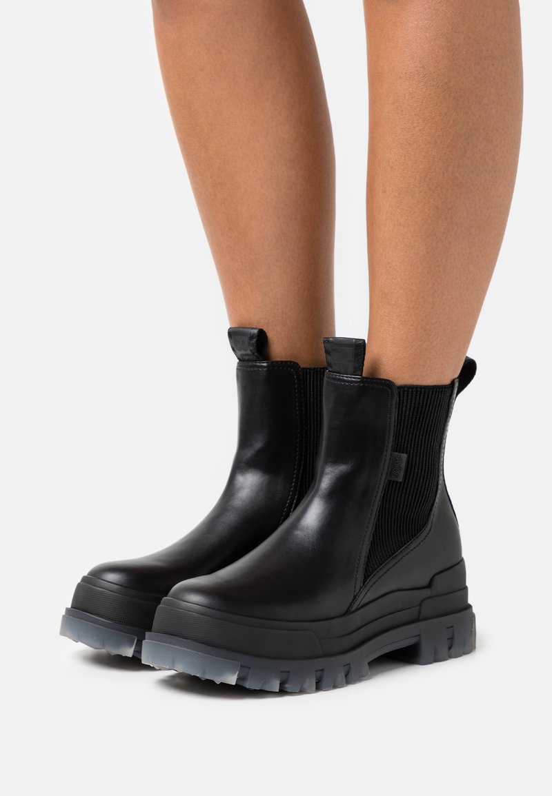 Buffalo ASPHA CHELSEA MID - Platform ankle boots - black/transparent ...