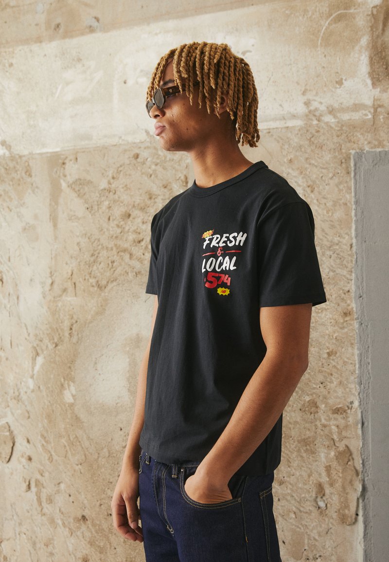 New Balance ESSENTIALS NOVELTY GRAPHIC - Print T-shirt - black - Zalando.ie