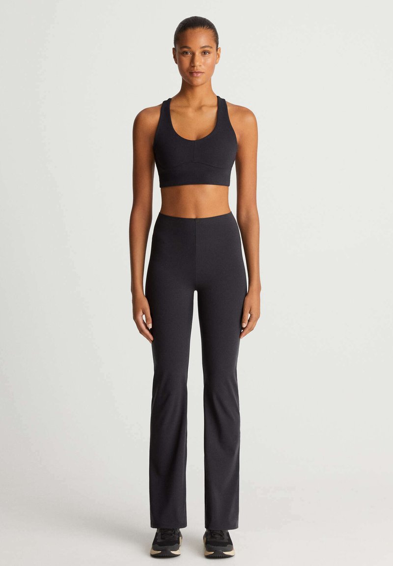 OYSHO RAISE UP COMPRESSIVE FLARE - Spodnie materiałowe - black/czarny ...