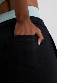 Calvin Klein Performance RELAXED WIDE LEG JOGGERS - Jogginghose - black ...