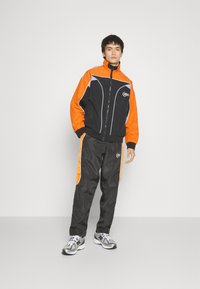 Night Addict NAMOON UNISEX - Pantaloni sportivi - black/orange/nero ...