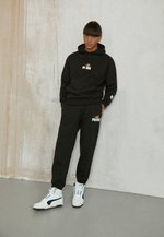 Puma PUMA X GARFIELD - Tracksuit bottoms - black - Zalando.de