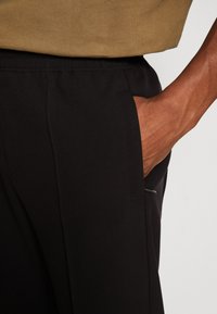 Weekday KEN TRACKPANTS UNISEX - Pantalones - black/negro - Zalando.es