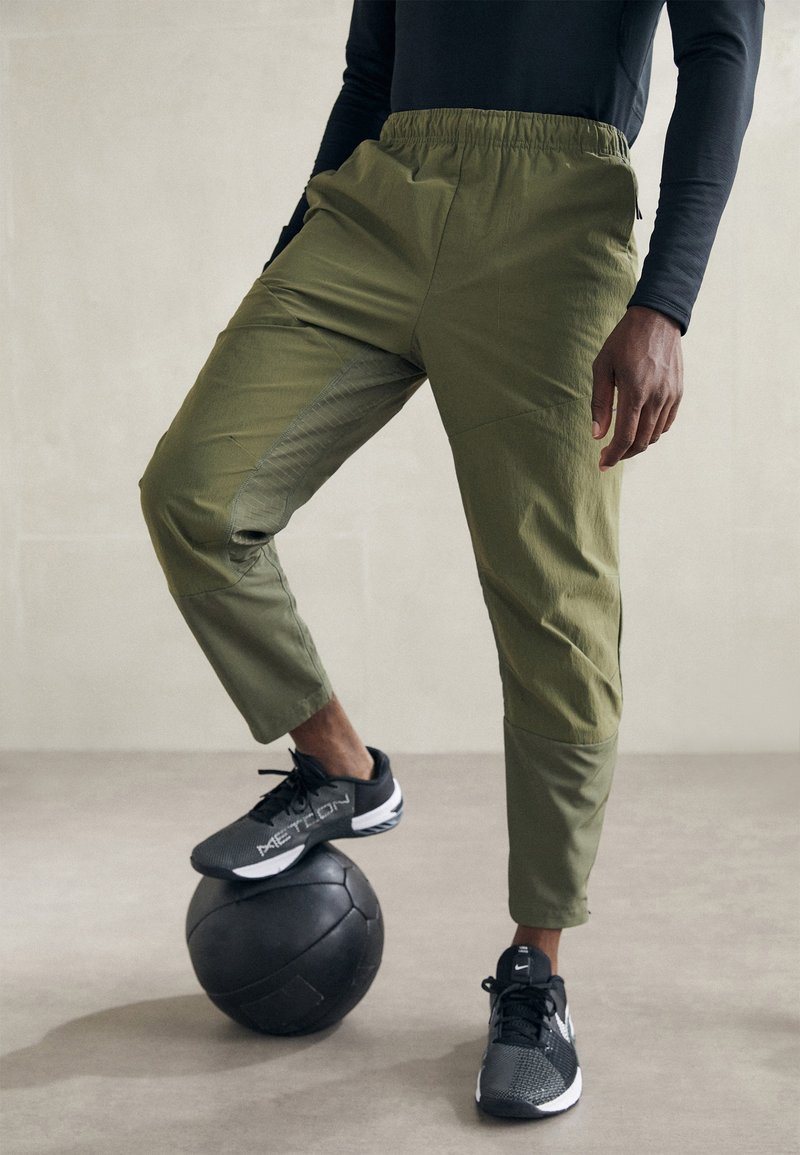 Nike Performance AXIS PANT - Tracksuit bottoms - medium olive/black ...