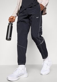 Nike Performance RETRO TRACK PANT - Jogginghose - black/reflective ...