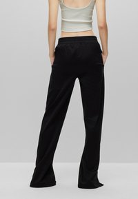 HUGO NELEGA - Pantalon de survêtement - black one/noir - ZALANDO.FR
