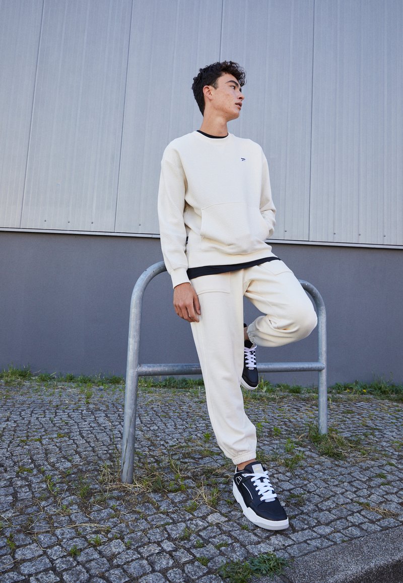 Puma DOWNTOWN - Tracksuit bottoms - off-white - Zalando.co.uk