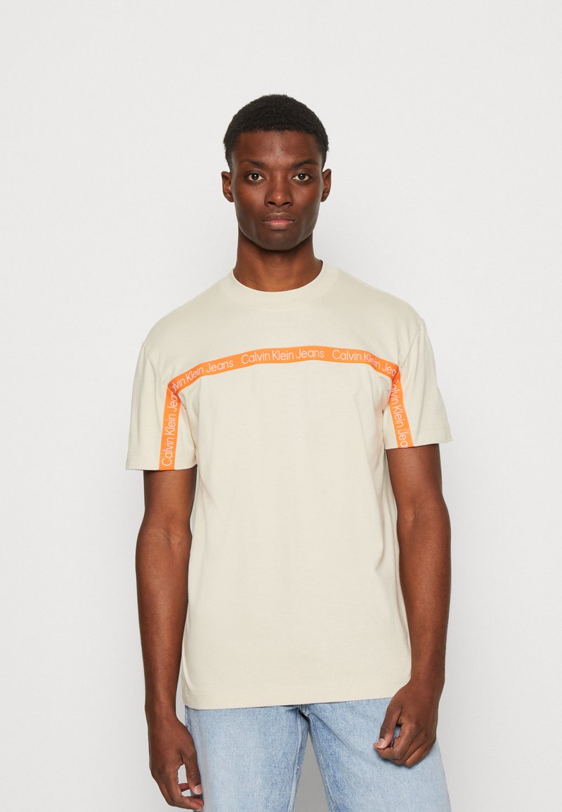 Calvin Klein Jeans LOGO TAPE - T-shirt con stampa - classic beige/beige ...