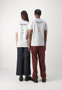Calvin Klein Jeans ECLIPSE GRAPHIC TEE UNISEX - T-Shirt print - lunar ...