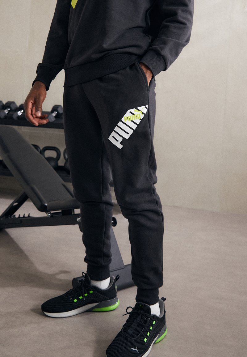 Puma POWER GRAPHIC - Tracksuit bottoms - black/lime sheen/black ...