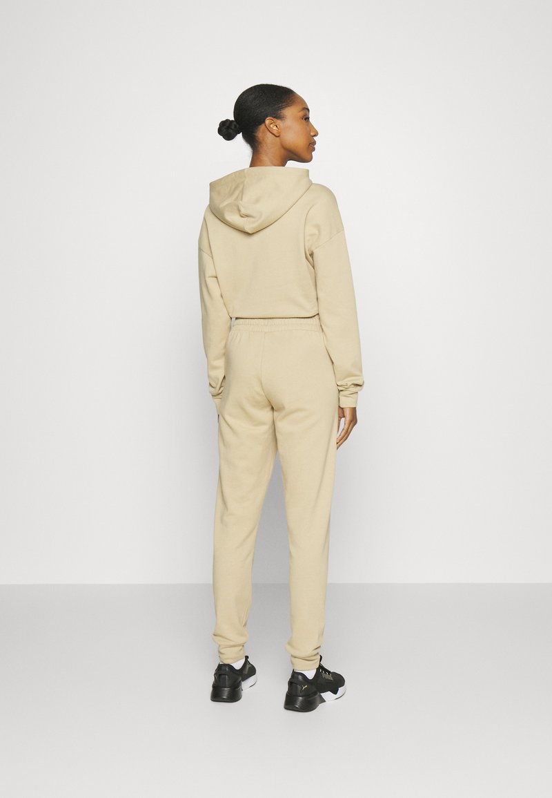 Puma BETTER ESSENTIALS - Pantalones deportivos - sand dune/beige ...