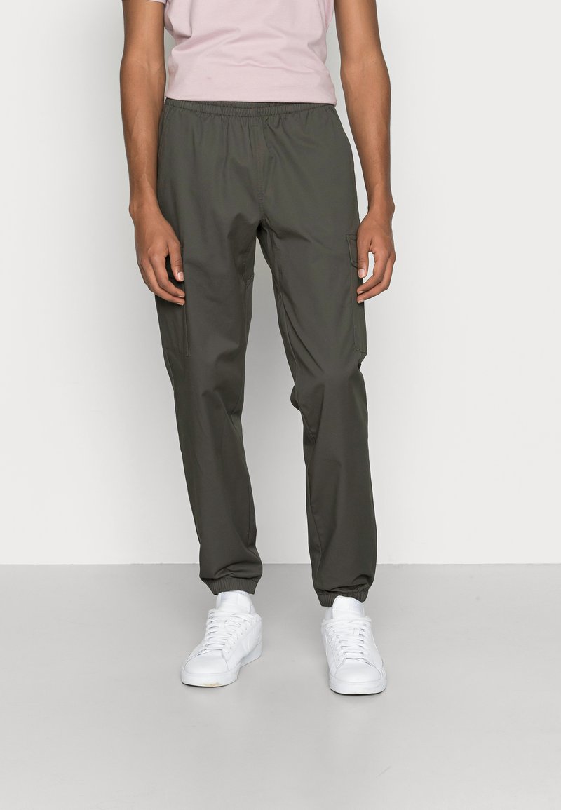 New Balance ATHLETICS - Pantalones cargo - camo green/multicolor ...
