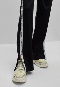 HUGO NELEGA - Pantalon de survêtement - black one/noir - ZALANDO.FR