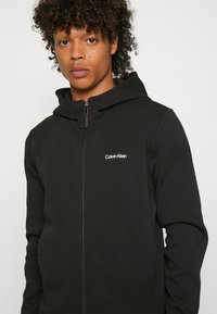 Calvin Klein MICRO LOGO REPREVE HOODIE JACKET - Felpa con zip - black ...